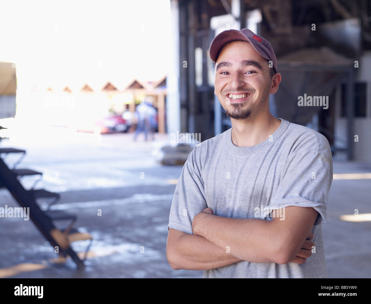 Hispanic worker smiling in factory Stock Photo - Alamy