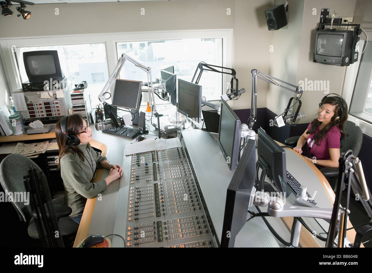 Asian dj working at radio station with co-worker Stock Photo - Alamy