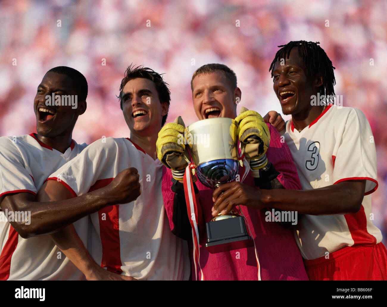 Soccer team triumphantly holding trophy Stock Photo - Alamy