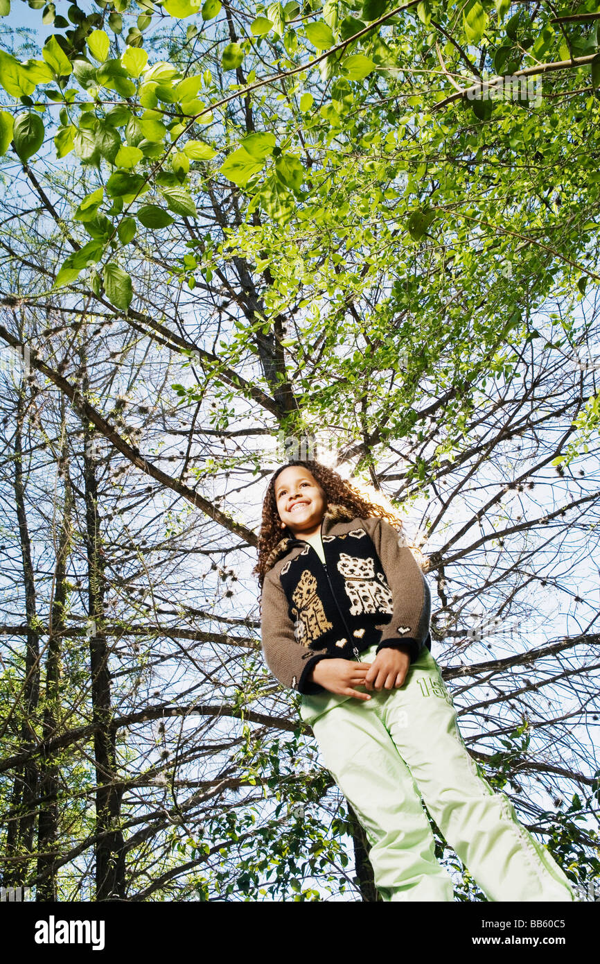 Low angle view of young girl under tree Stock Photo - Alamy