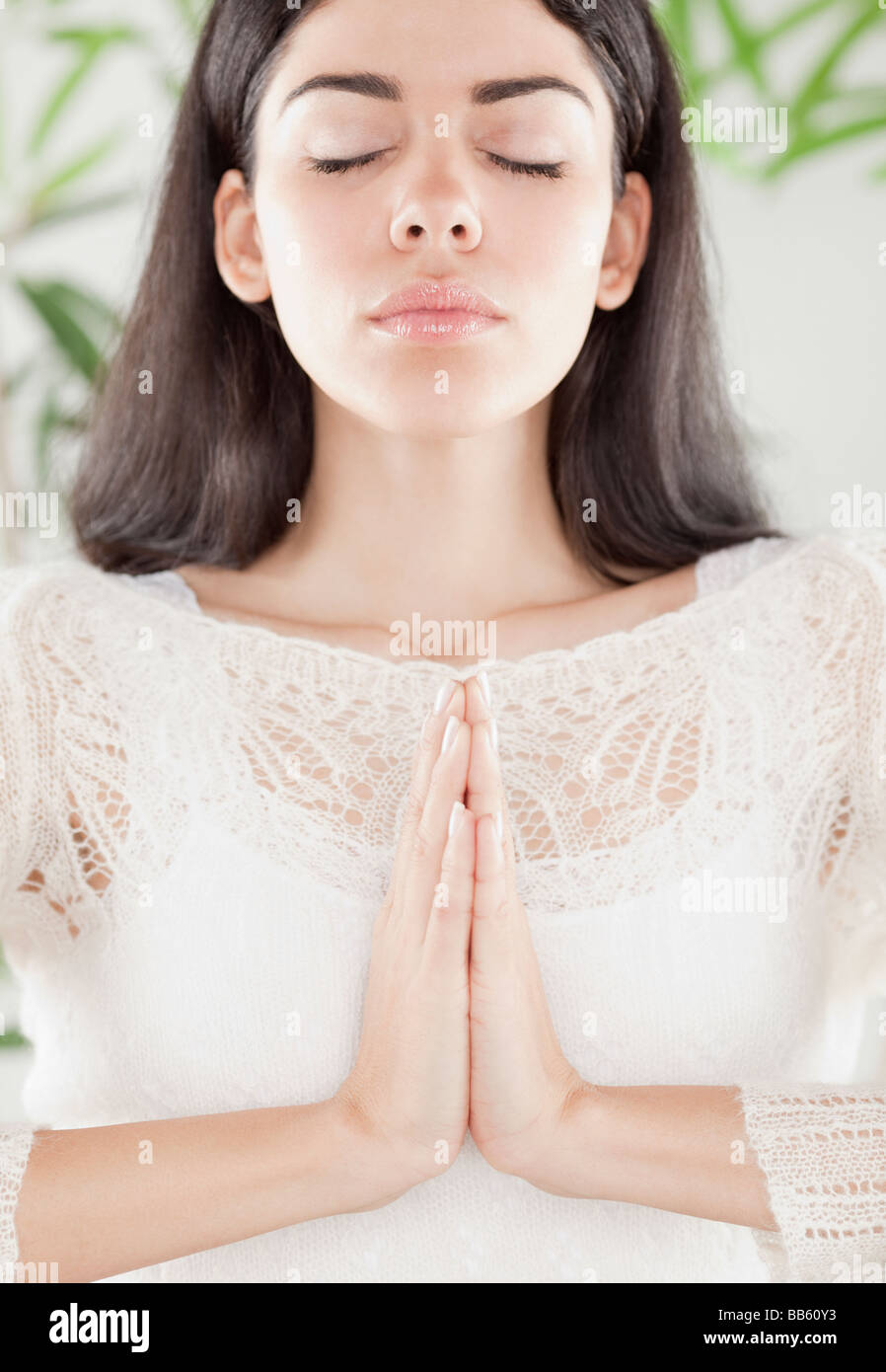 Hispanic woman praying Stock Photo - Alamy