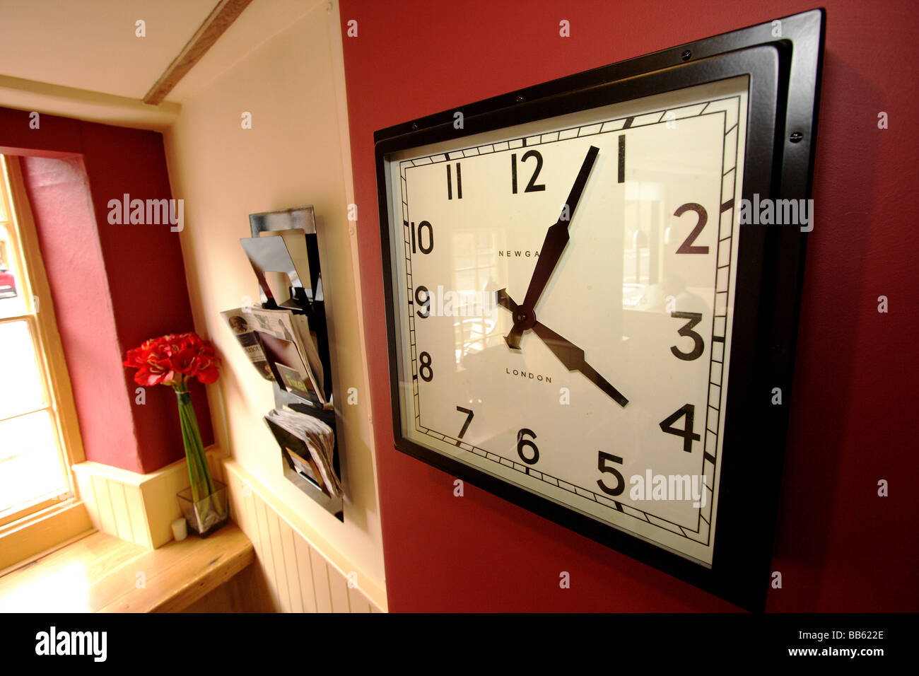 A square wall clock taken witha wide angle lens to enhance the ...