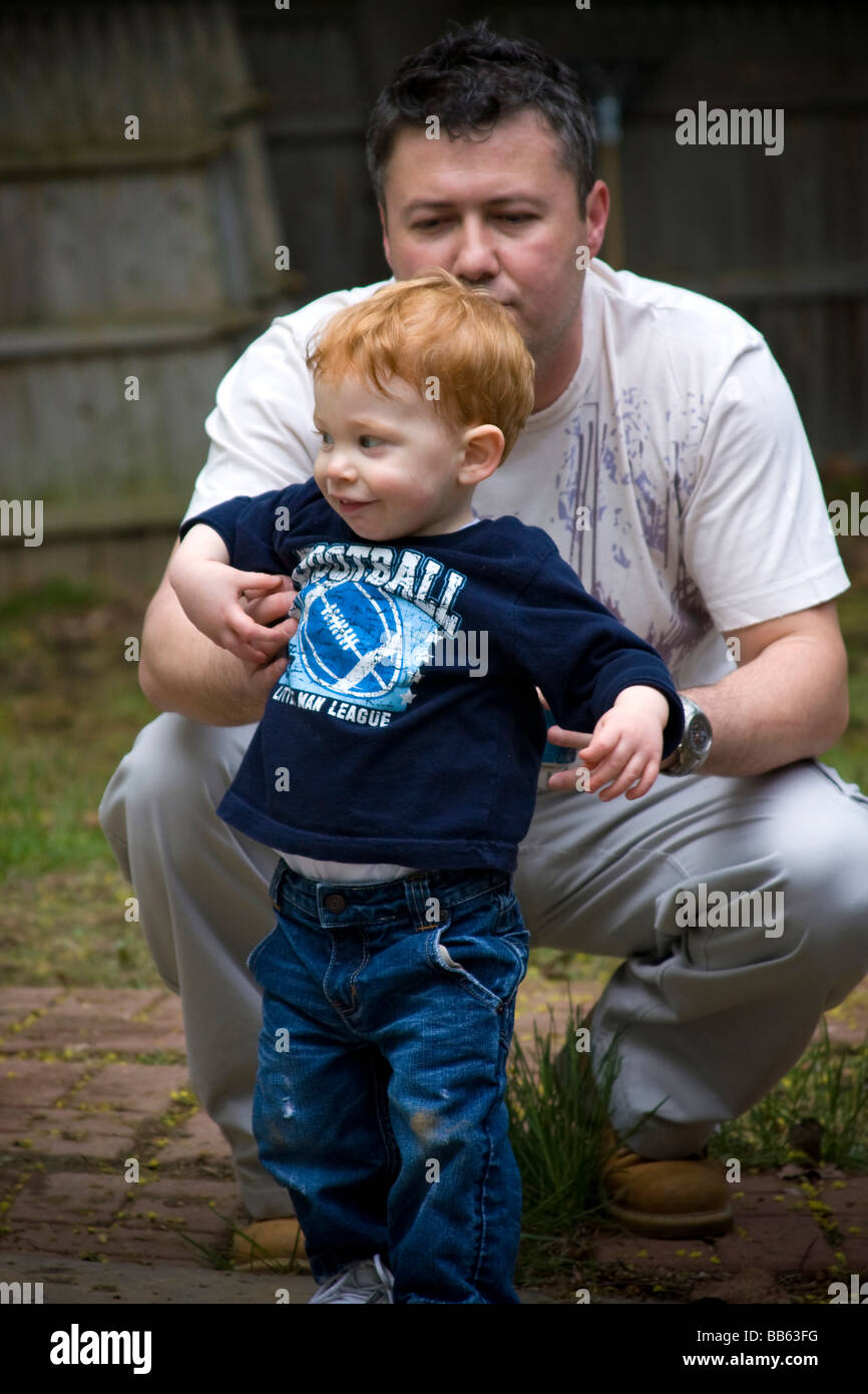 Happy baby learning to walk with help Stock Photo - Alamy