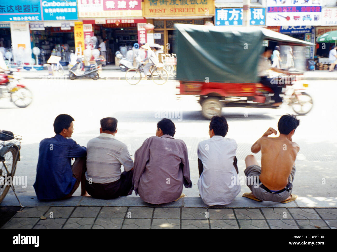 men sitting on pavement, China Stock Photo - Alamy