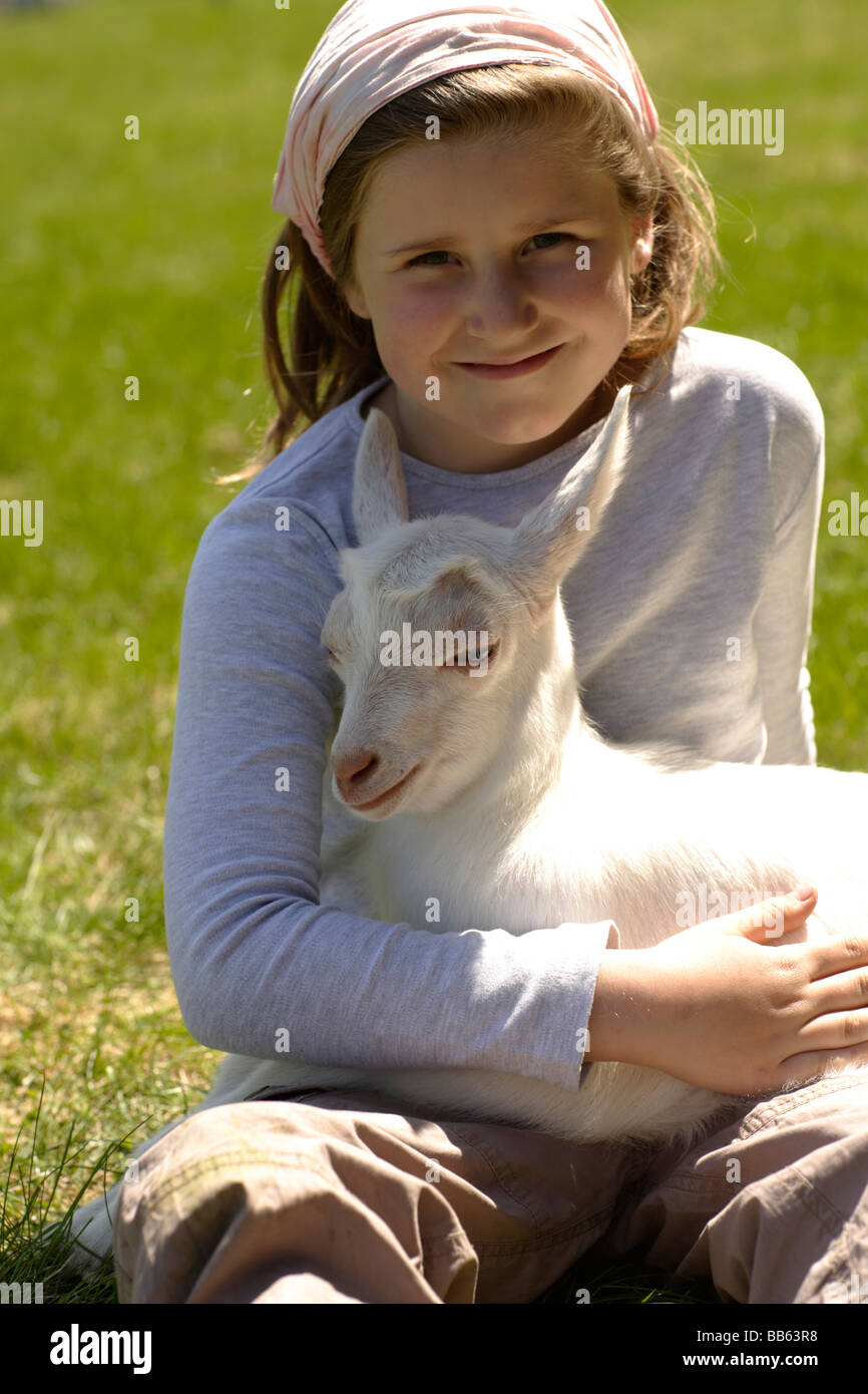 Girl hugging goat in grass Stock Photo - Alamy