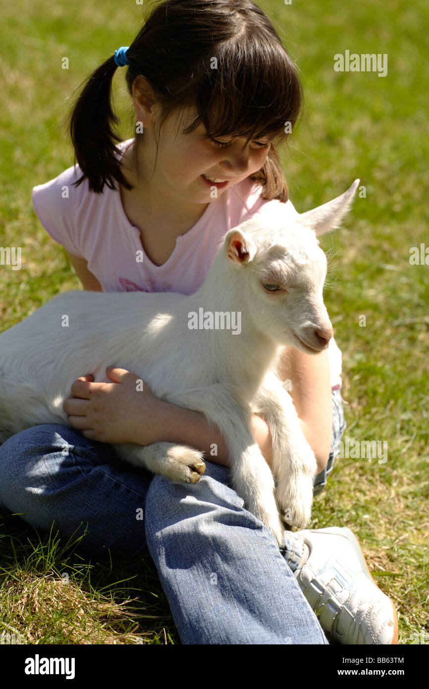 Girl hugging goat in grass Stock Photo - Alamy