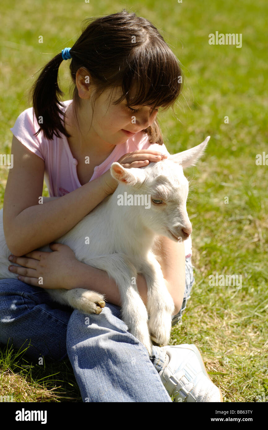 Girl hugging goat in grass Stock Photo - Alamy