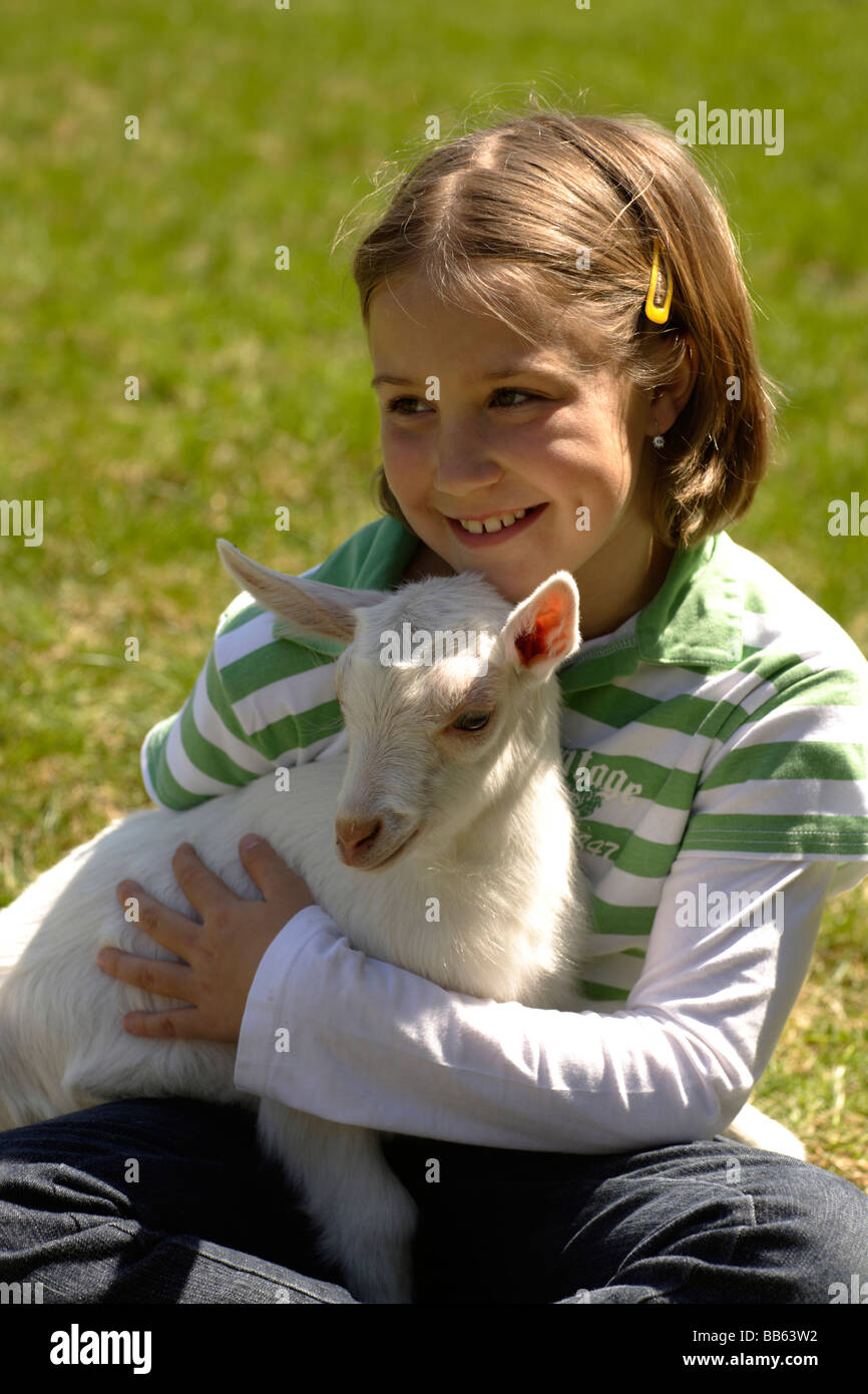 Girl hugging goat in grass Stock Photo - Alamy