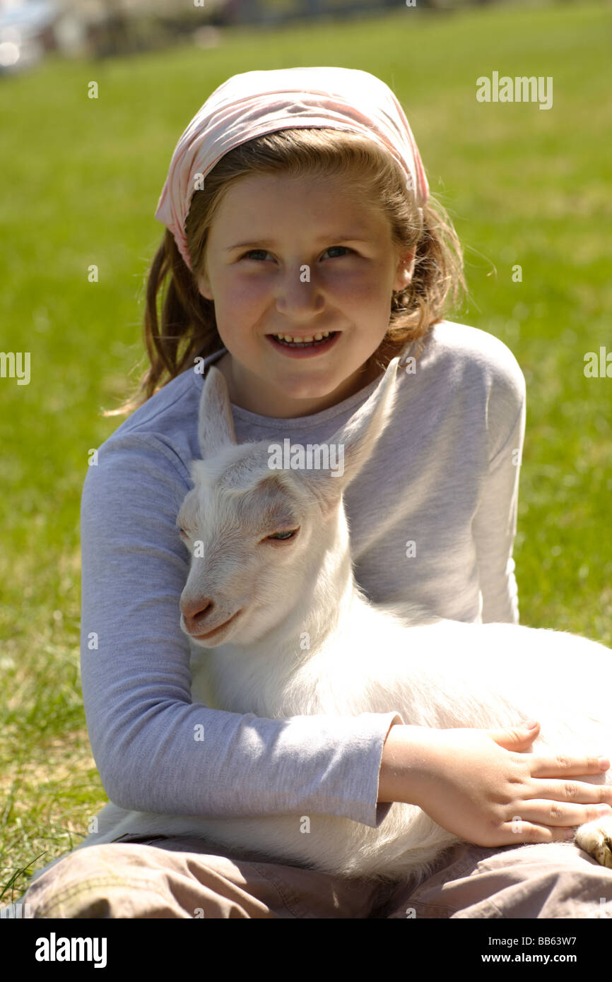 Girl hugging goat in grass Stock Photo - Alamy