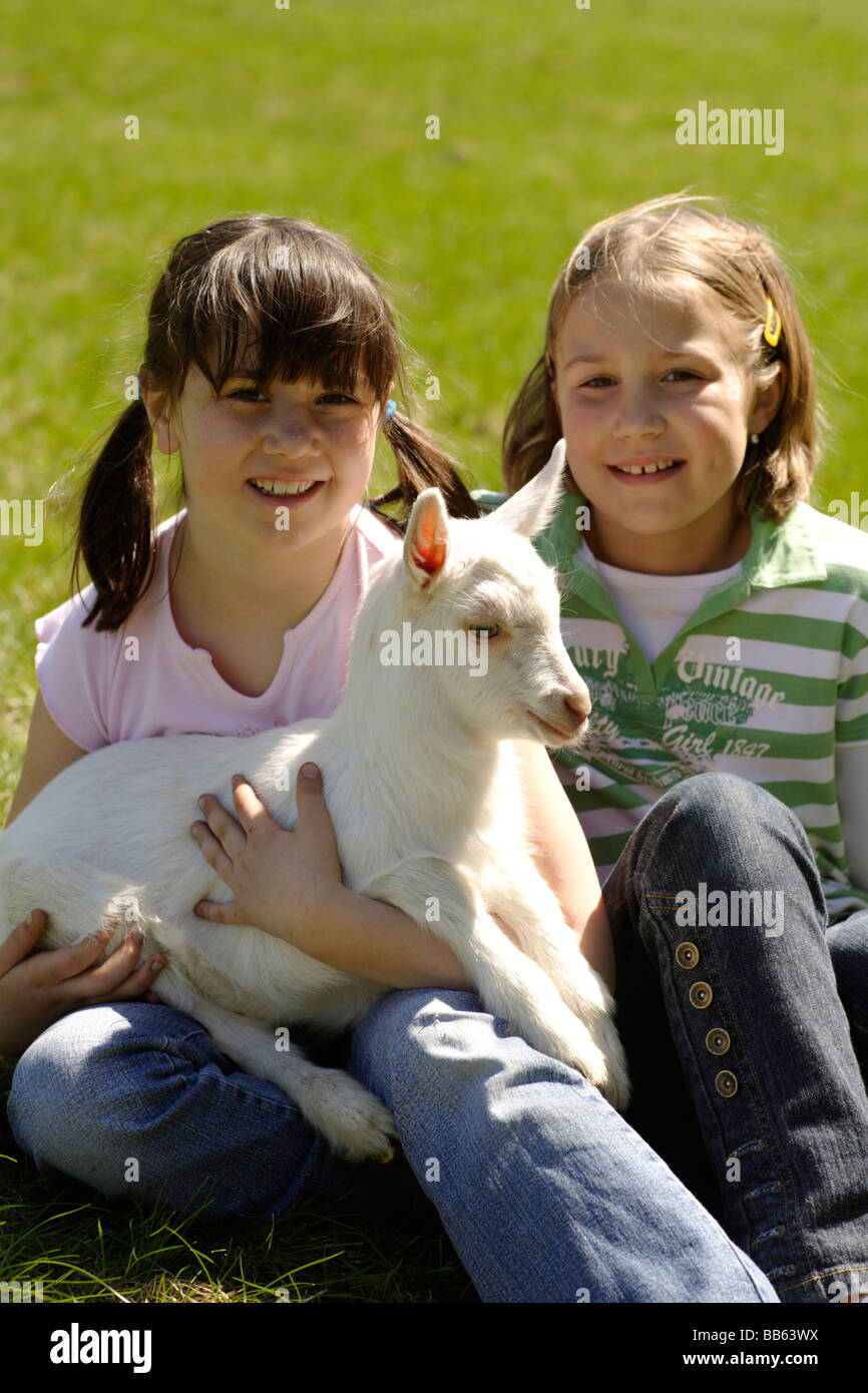 girl holding a goat in his arms on the meadow Stock Photo - Alamy