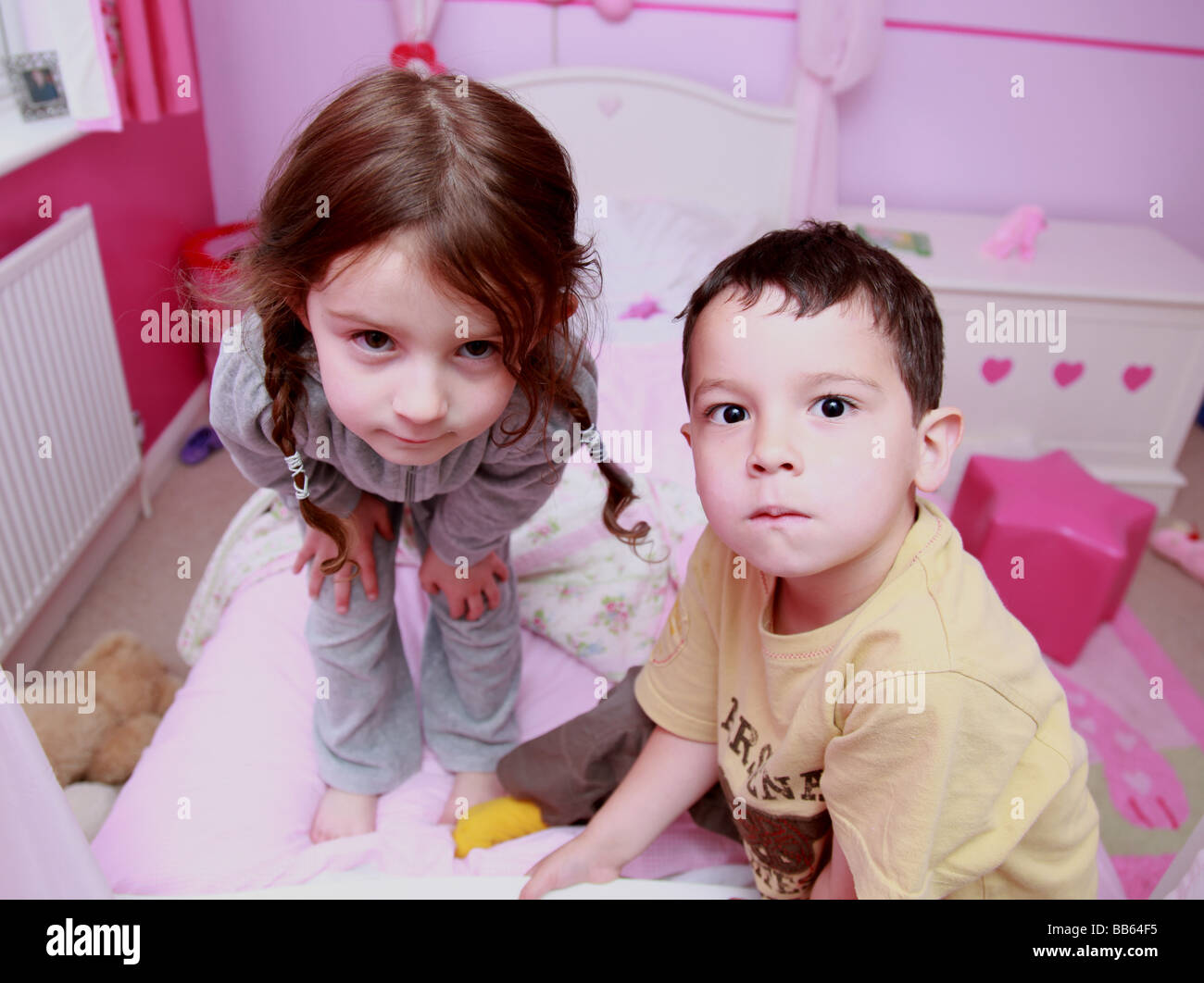 2 cheeky children staring into the camera Stock Photo - Alamy