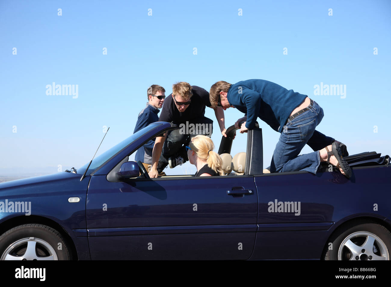 Group of young people getting into convertible car Stock Photo - Alamy