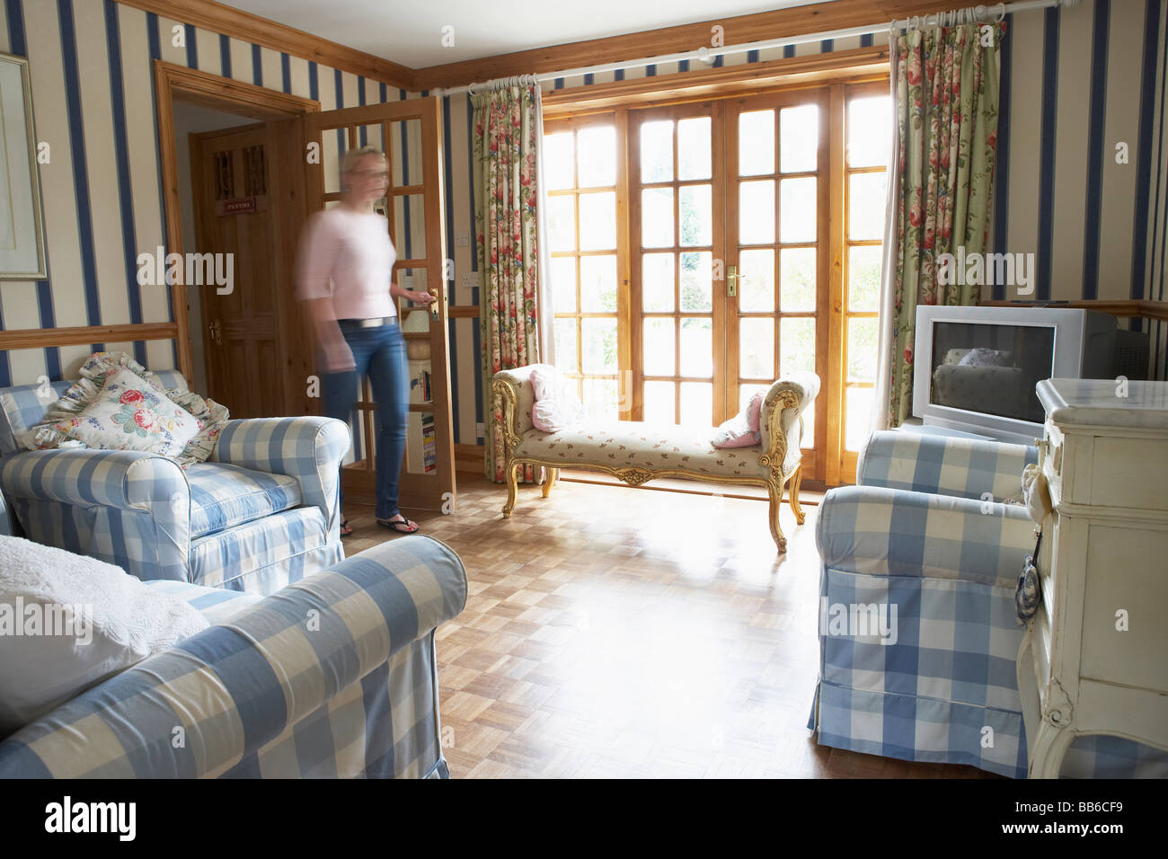 Woman Walking Through Lounge Stock Photo - Alamy