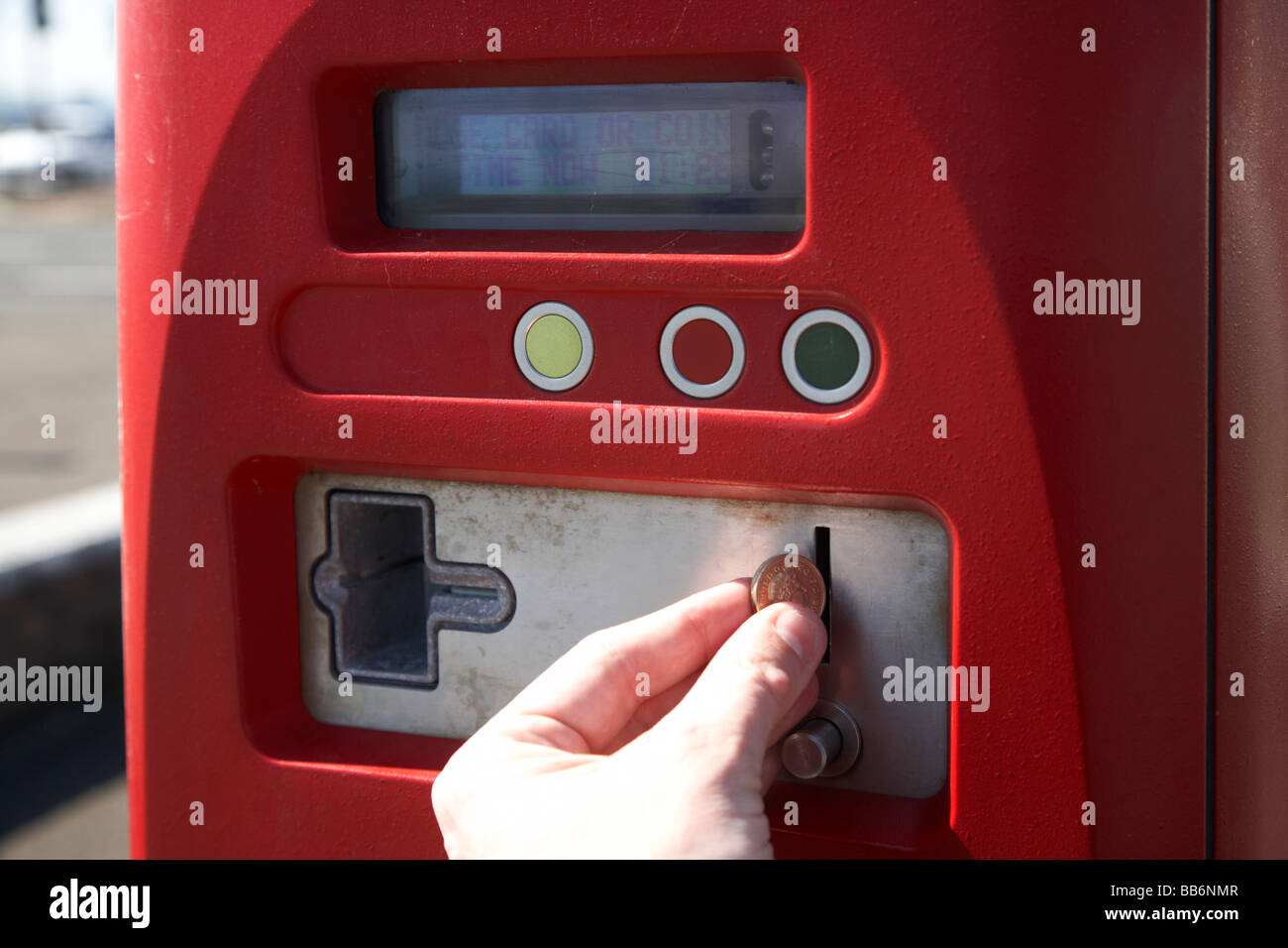 man putting pound coin into pay and display parking machine in the uk ...