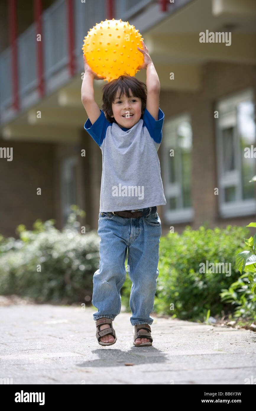 Little boy throwing a yellow ball Stock Photo - Alamy