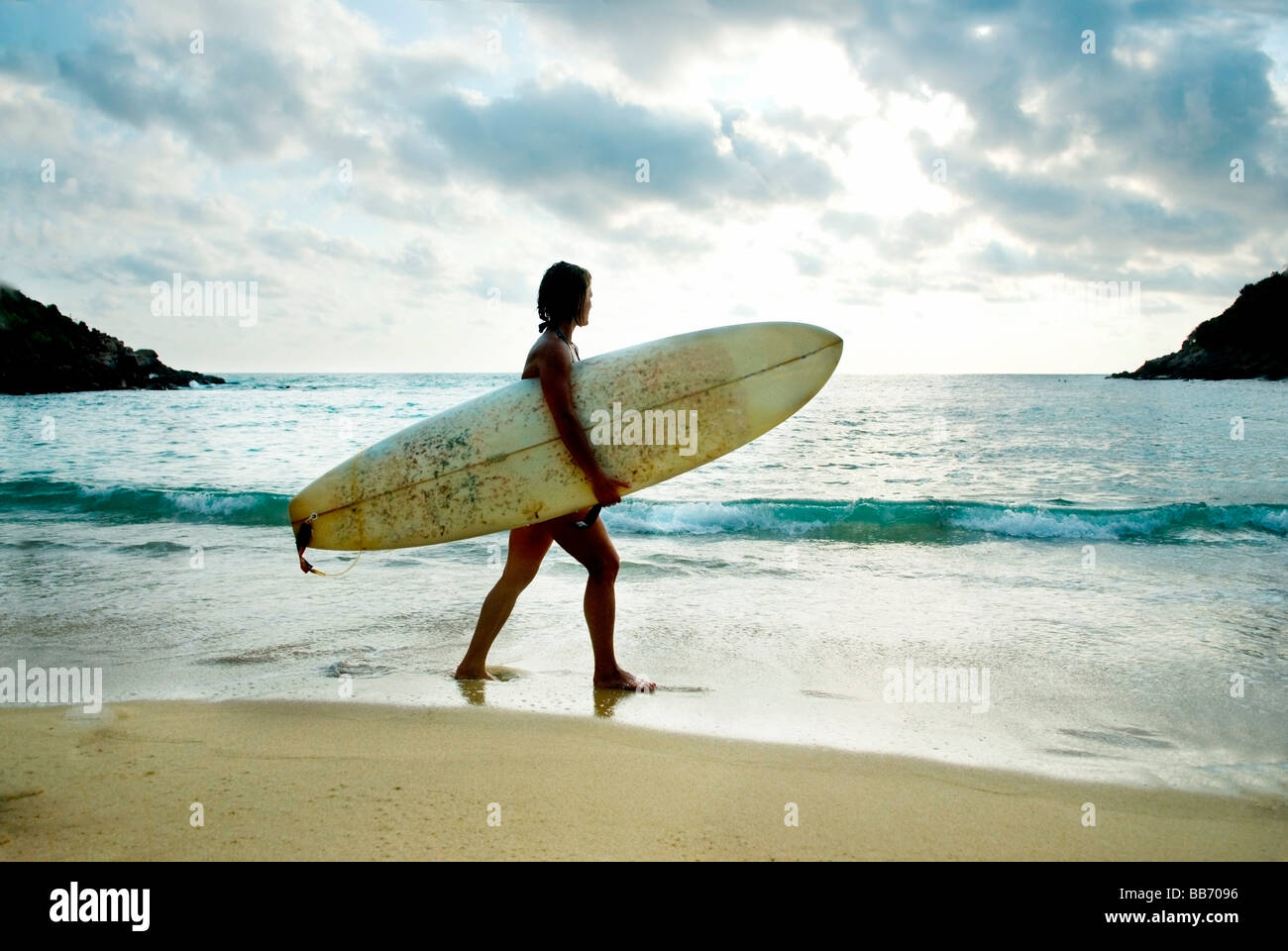 Man carrying surfboard on beach; Mexico Stock Photo - Alamy