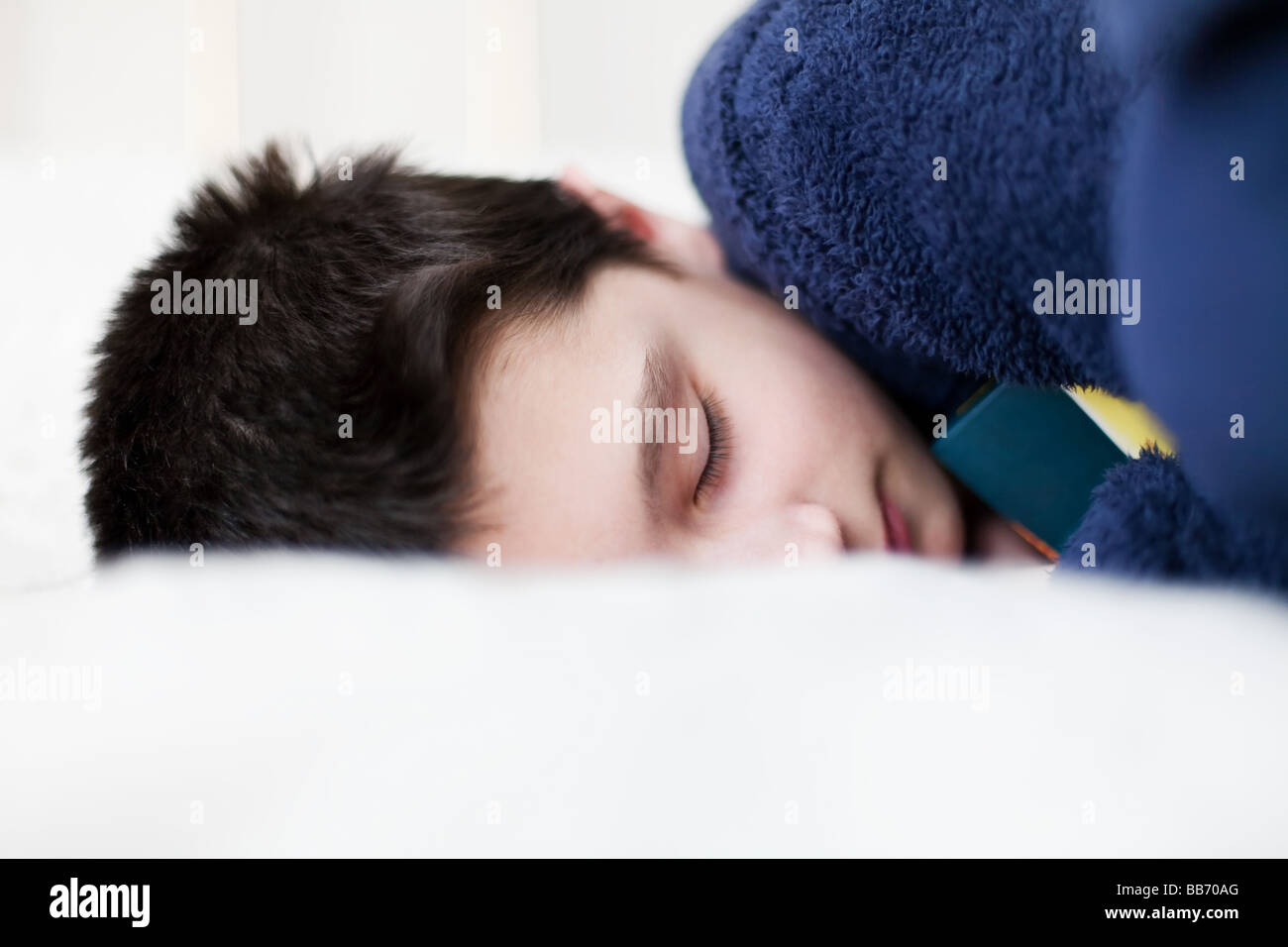 Young boy fast asleep on a bed Stock Photo - Alamy
