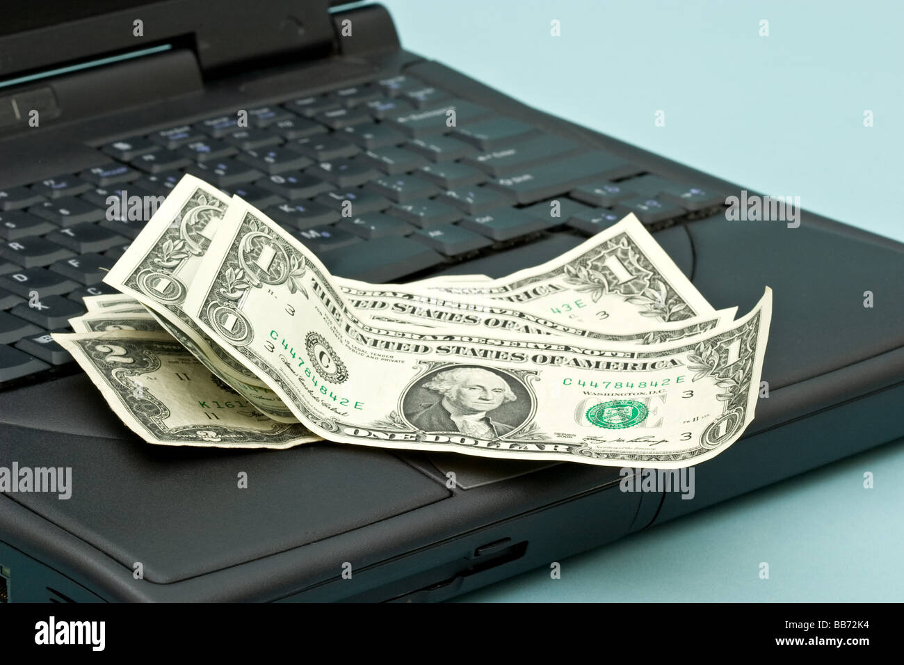 American dollar bills on a laptop computer keyboard Stock Photo - Alamy