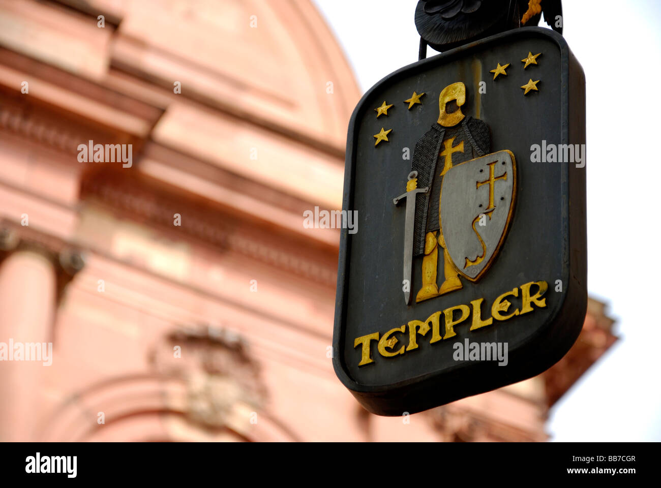 Restaurant sign with figure of a knight with an old European church ...