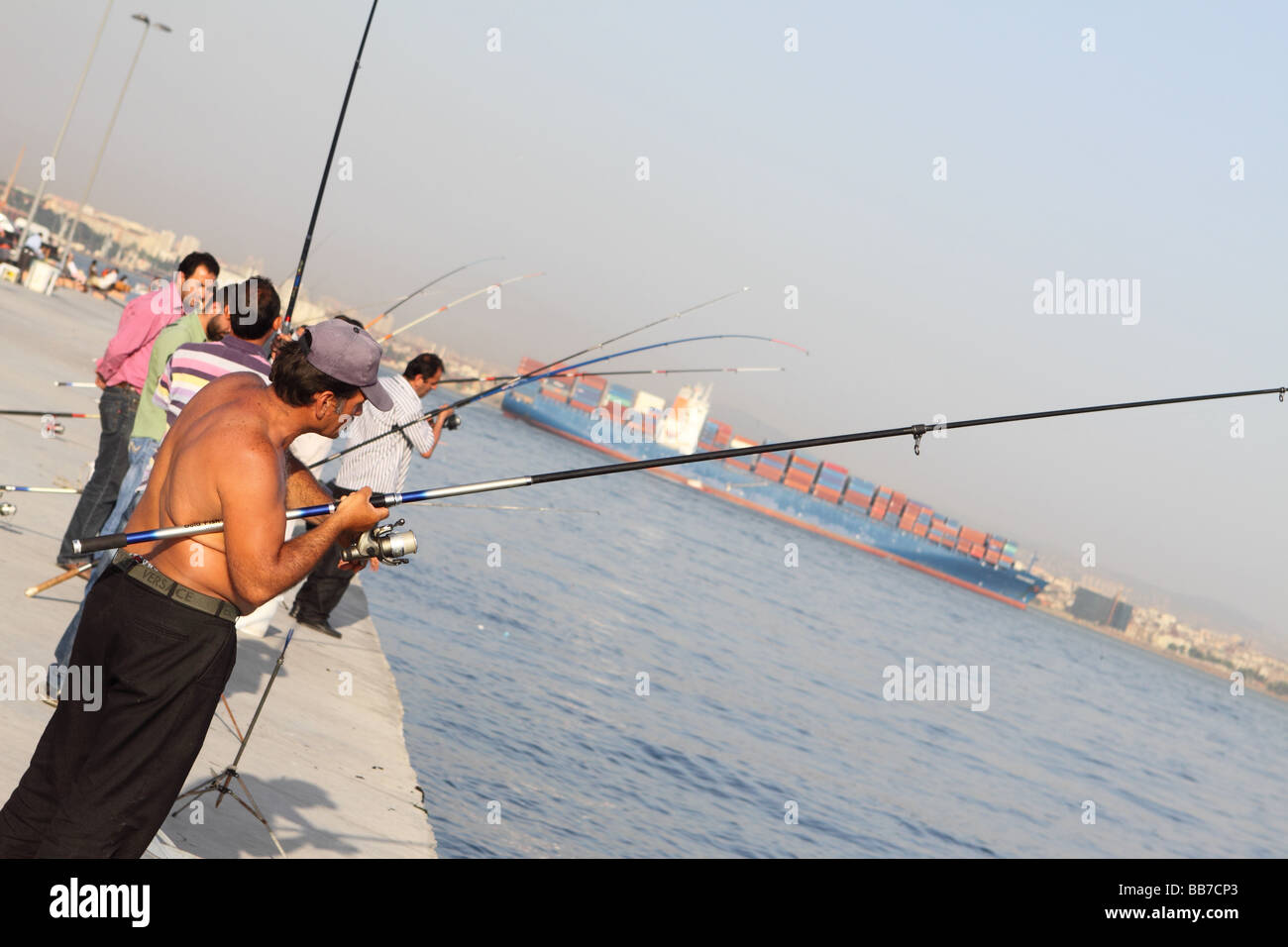 Istanbul Turkey men fishing on the sea front at Kumkapi with large ...