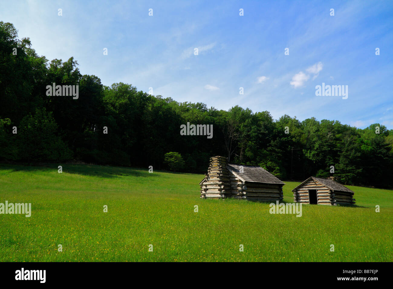 Two Revolutionary War log cabins on a sloping grass field Stock Photo ...