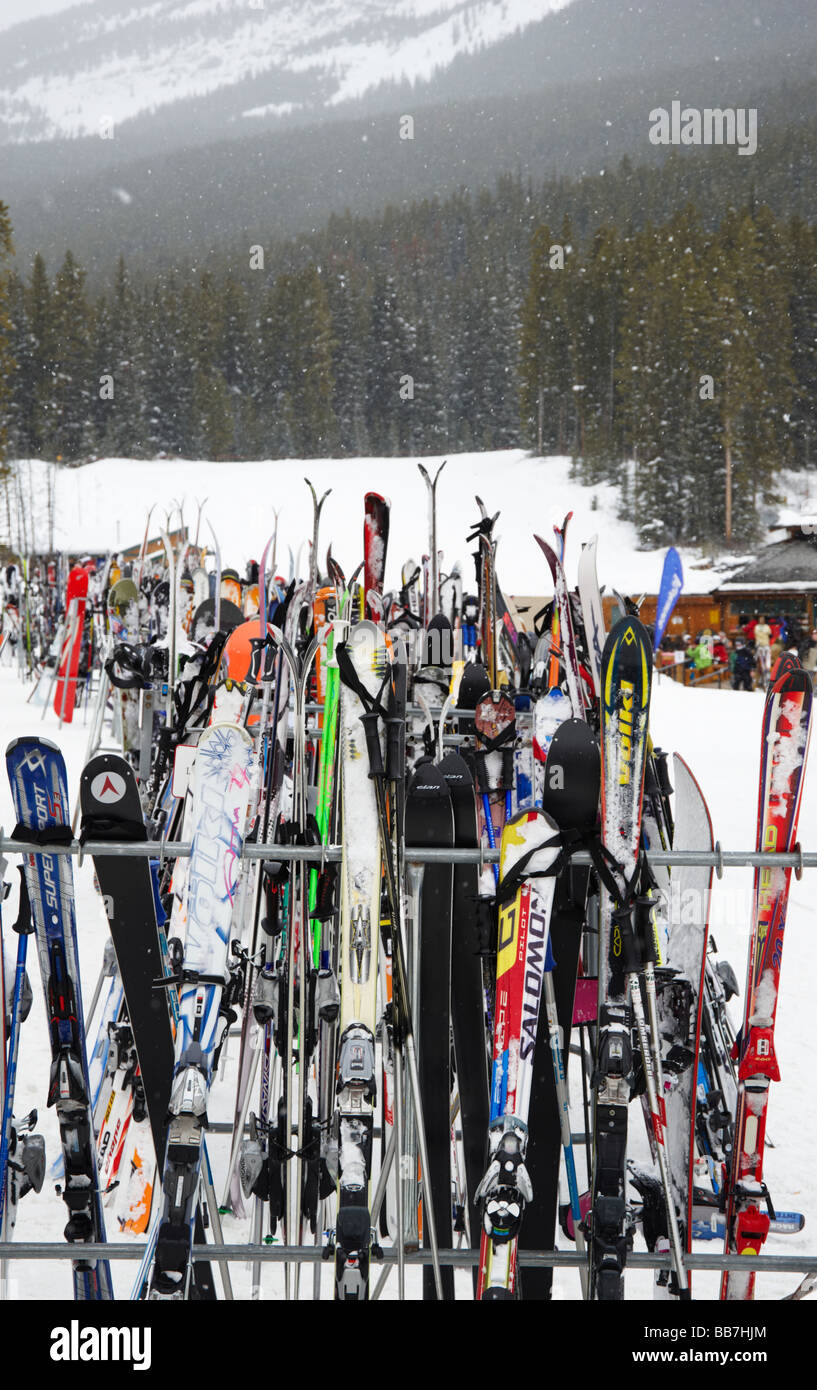 Skis and ski poles leaning against rack at ski resort, Lake Louise ...
