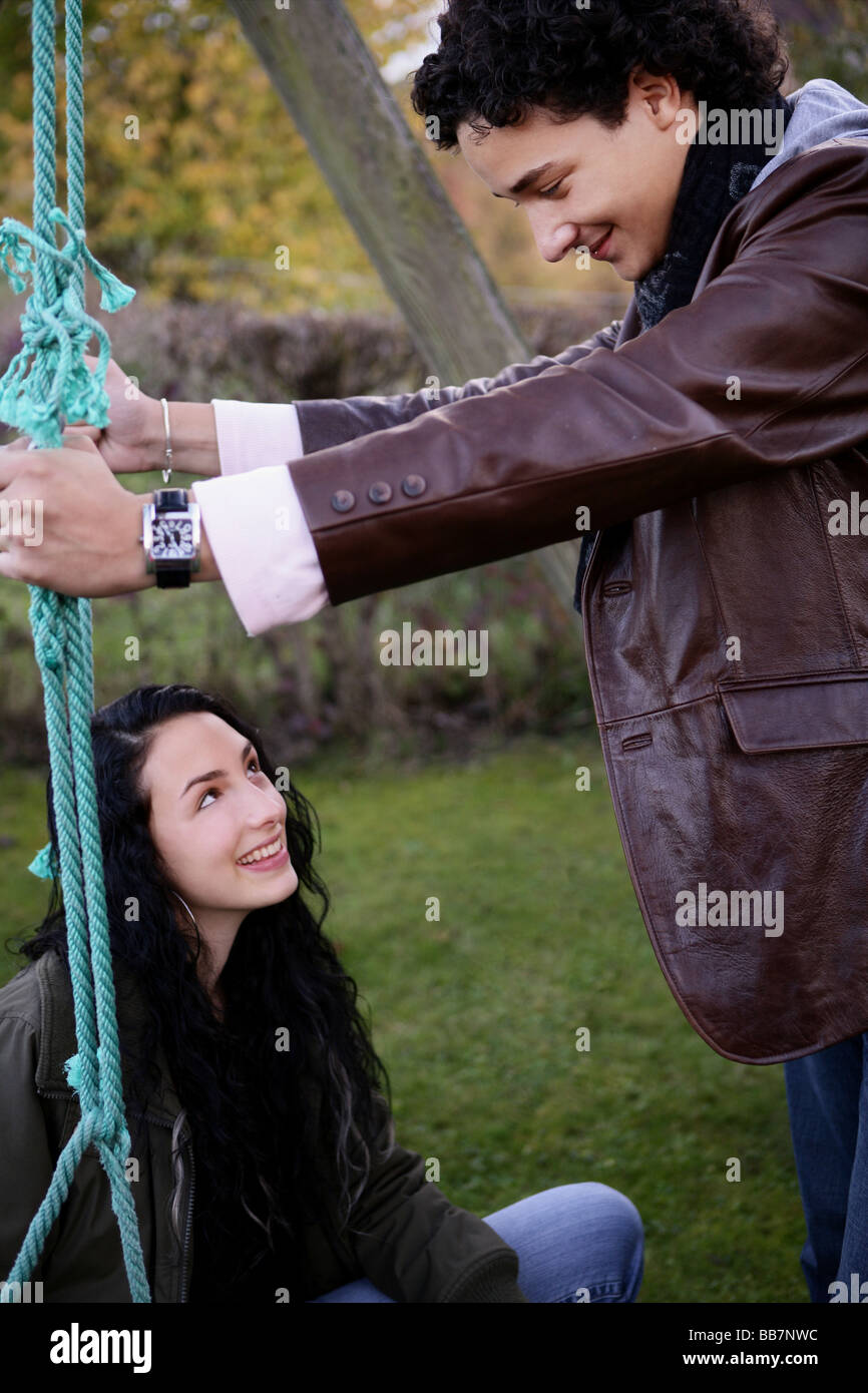 Teenager couple by a swing set Stock Photo - Alamy