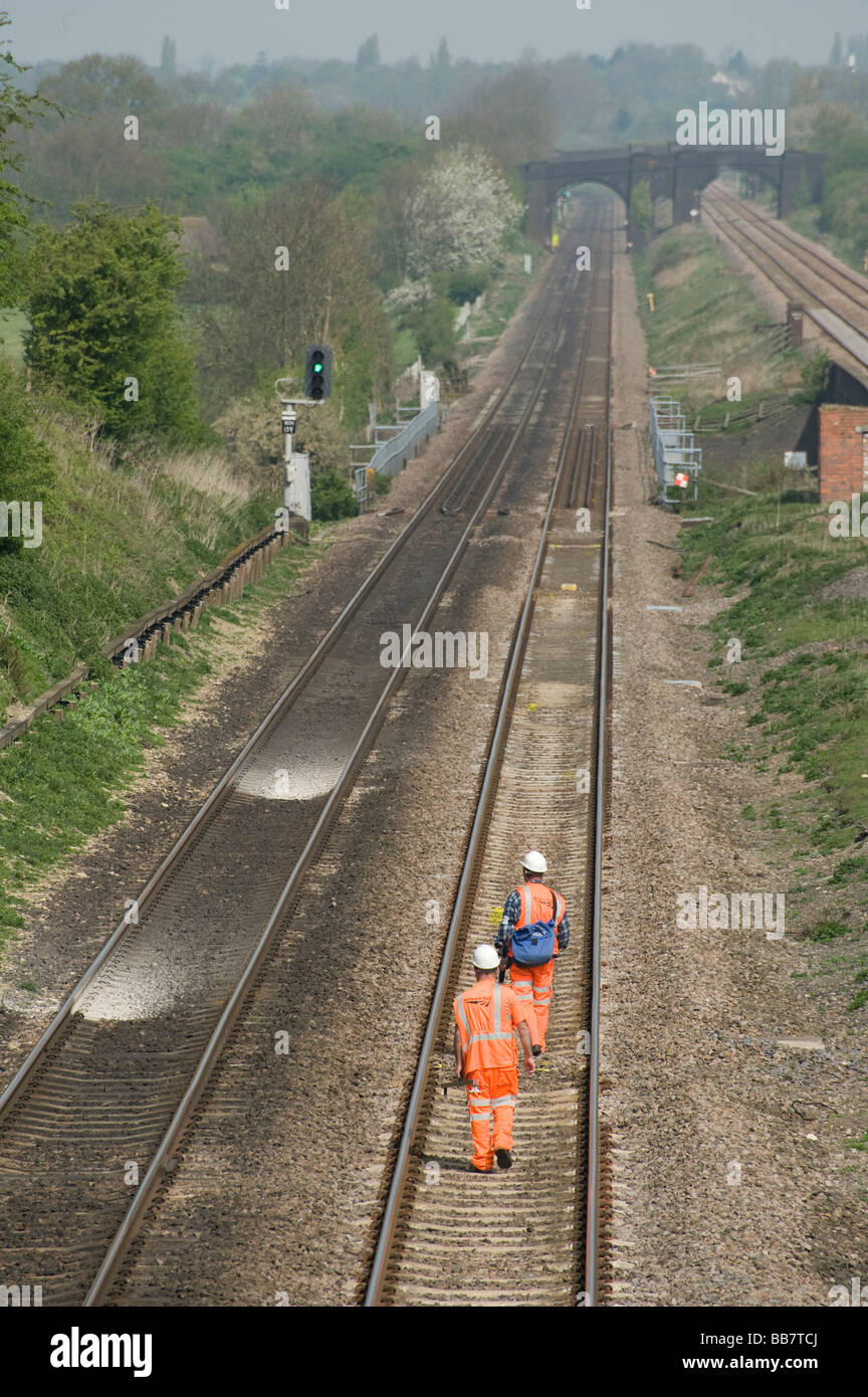 Railway workers from Network Rail walking along rail track in England ...