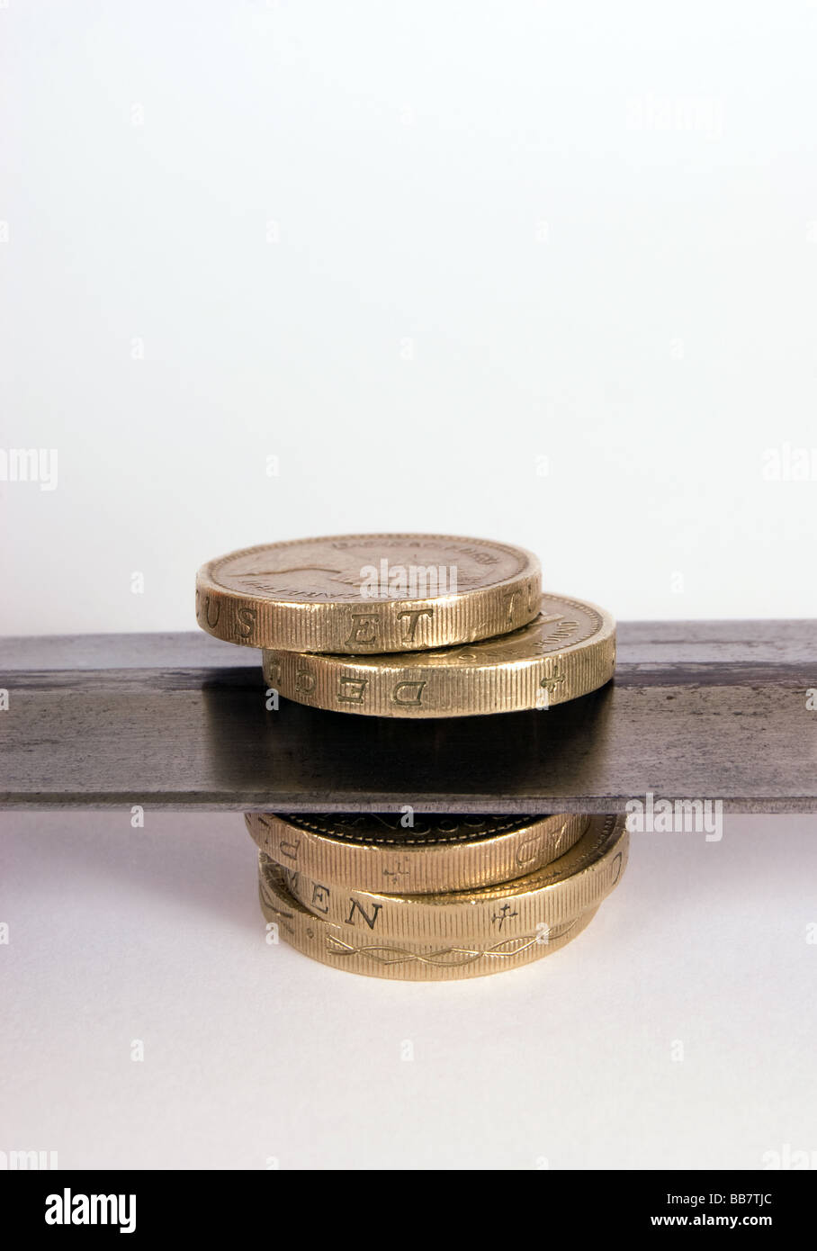 Knife cutting through a stack of one pound coins Stock Photo - Alamy