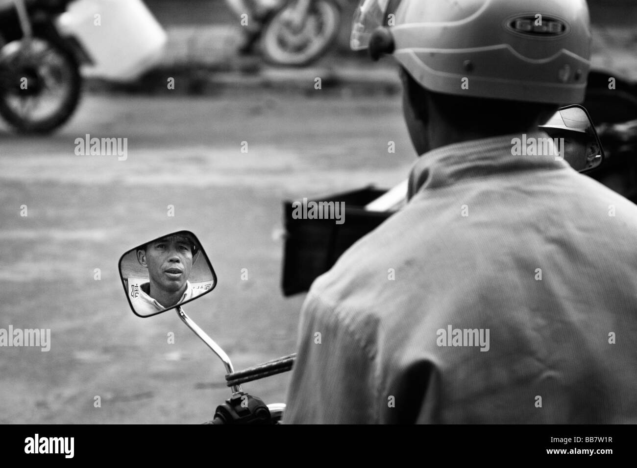 A man sits on his motorbike in the hamlet of Menghun, Xishuangbanna ...