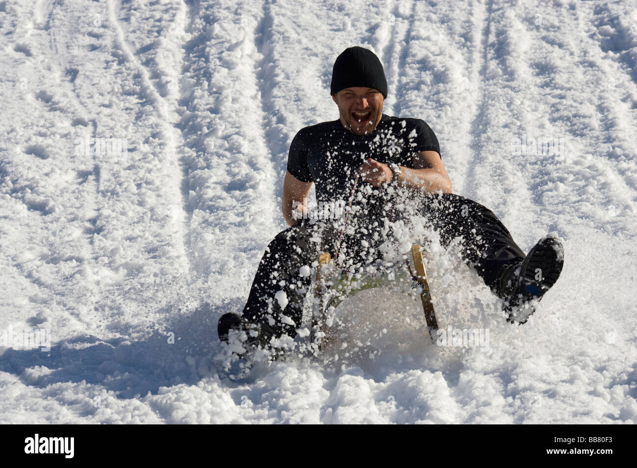 Man sledging down a hill, wearing a t-shirt, Zillertal, Austria Stock ...