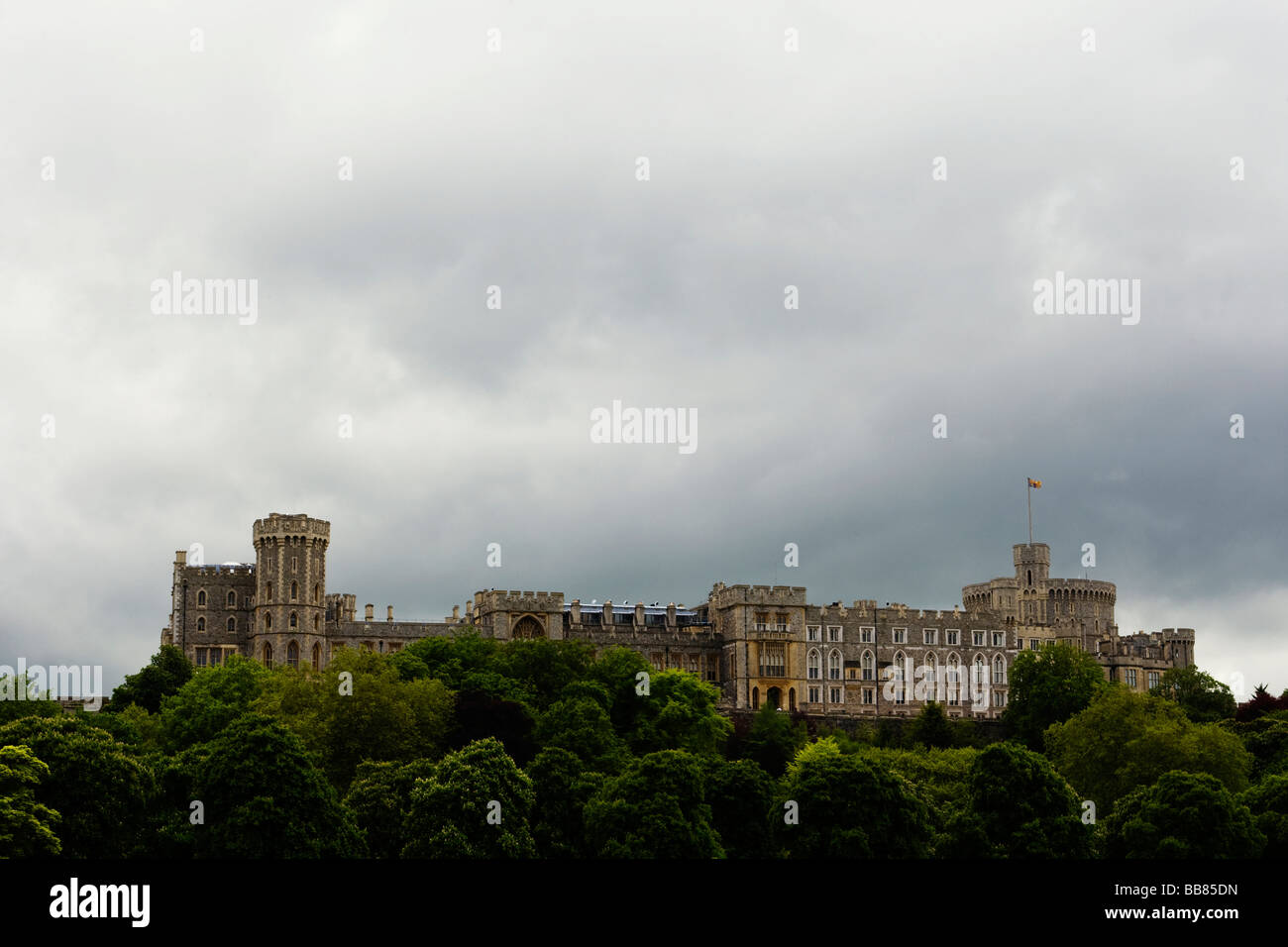 Windsor Castle with storm clouds above and the Queen's Standard flying ...