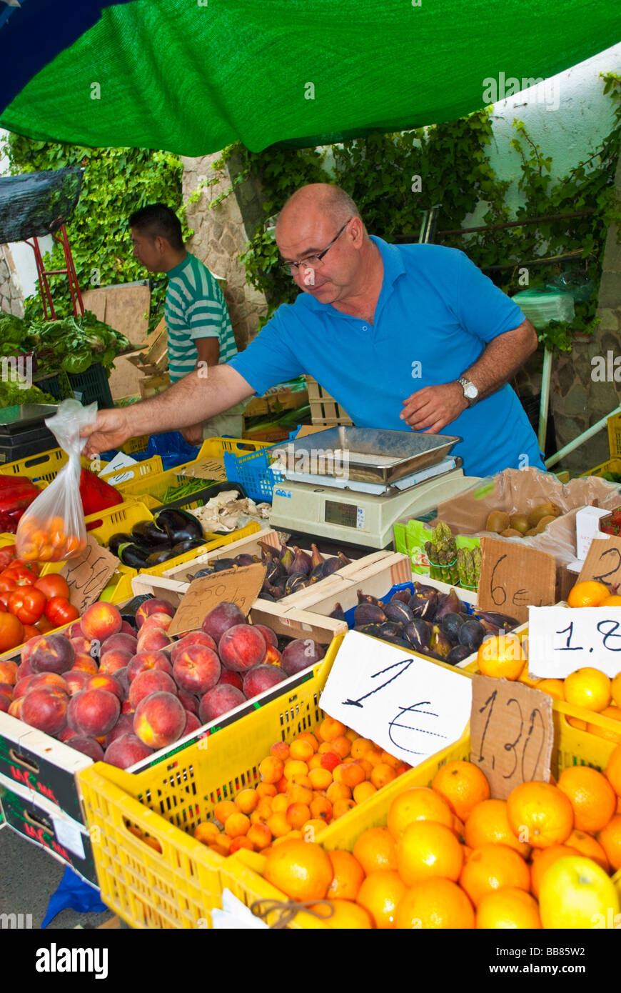 Salesman on vegetable and fruit stand at market at L Estartit Costa ...