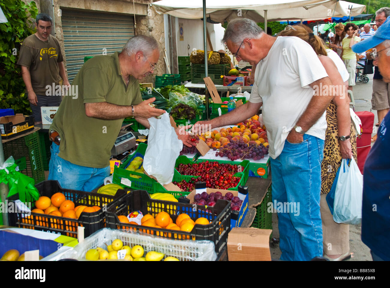 Salesman on vegetable and fruit stand at market at L Estartit Costa ...
