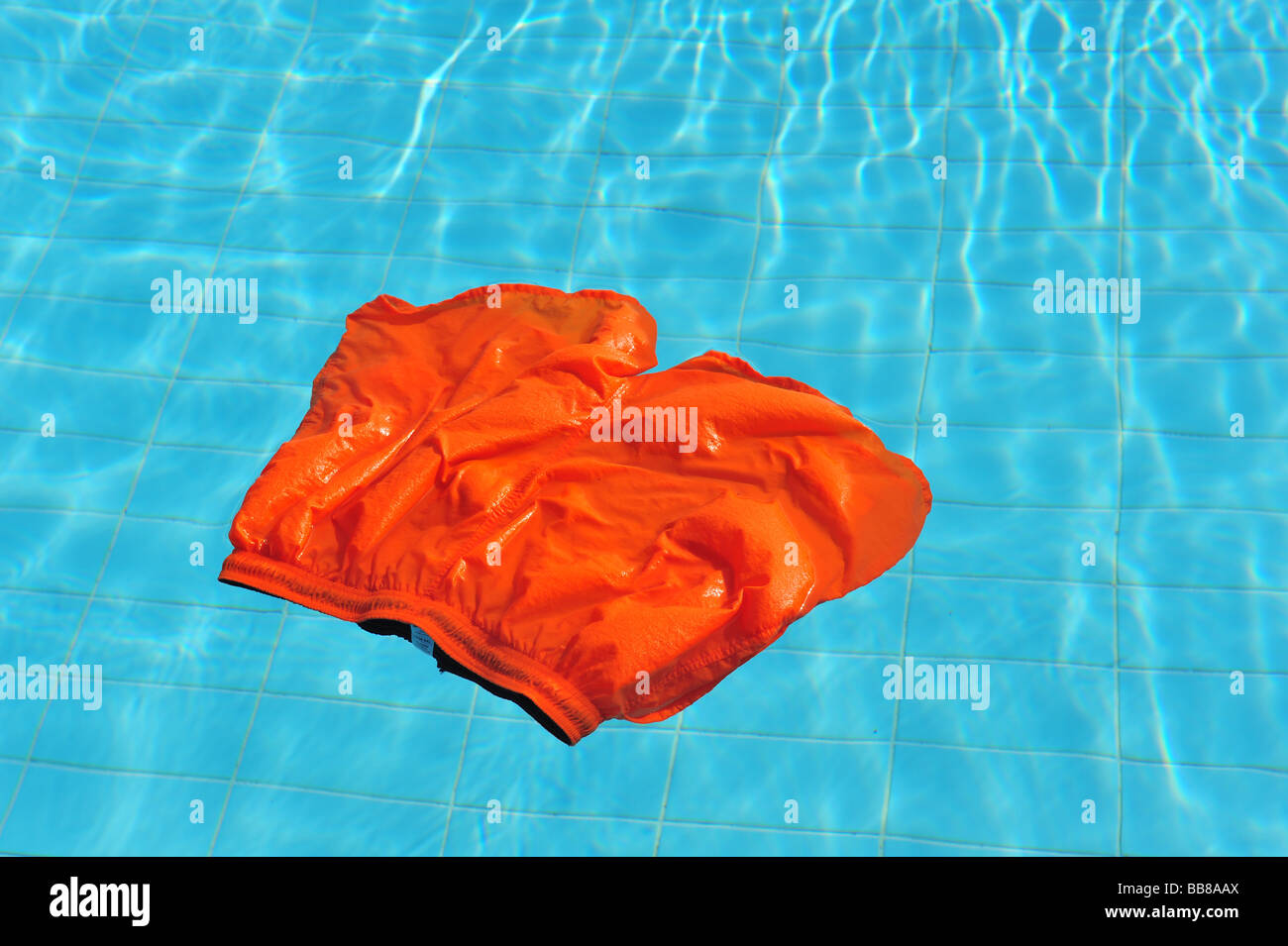 Orange swimming shorts floating on the swimming pool surface Stock ...