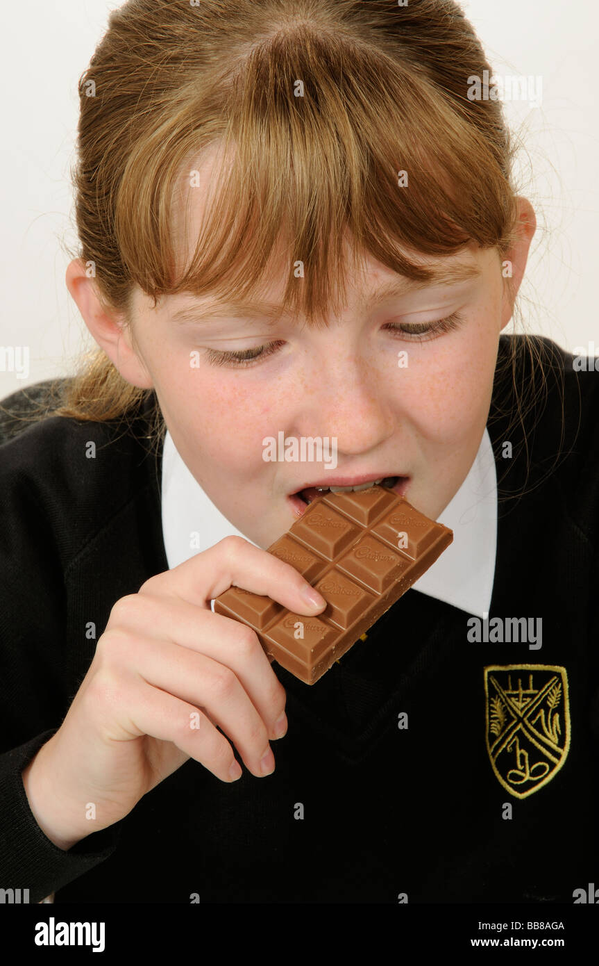 Schoolgirl eating a chocolate bar Stock Photo - Alamy