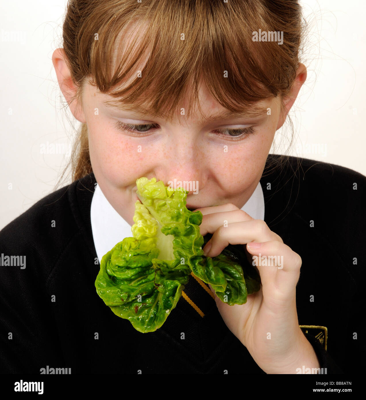 Schoolgirl eating a lettuce leaf a healthy salad filling Stock Photo ...