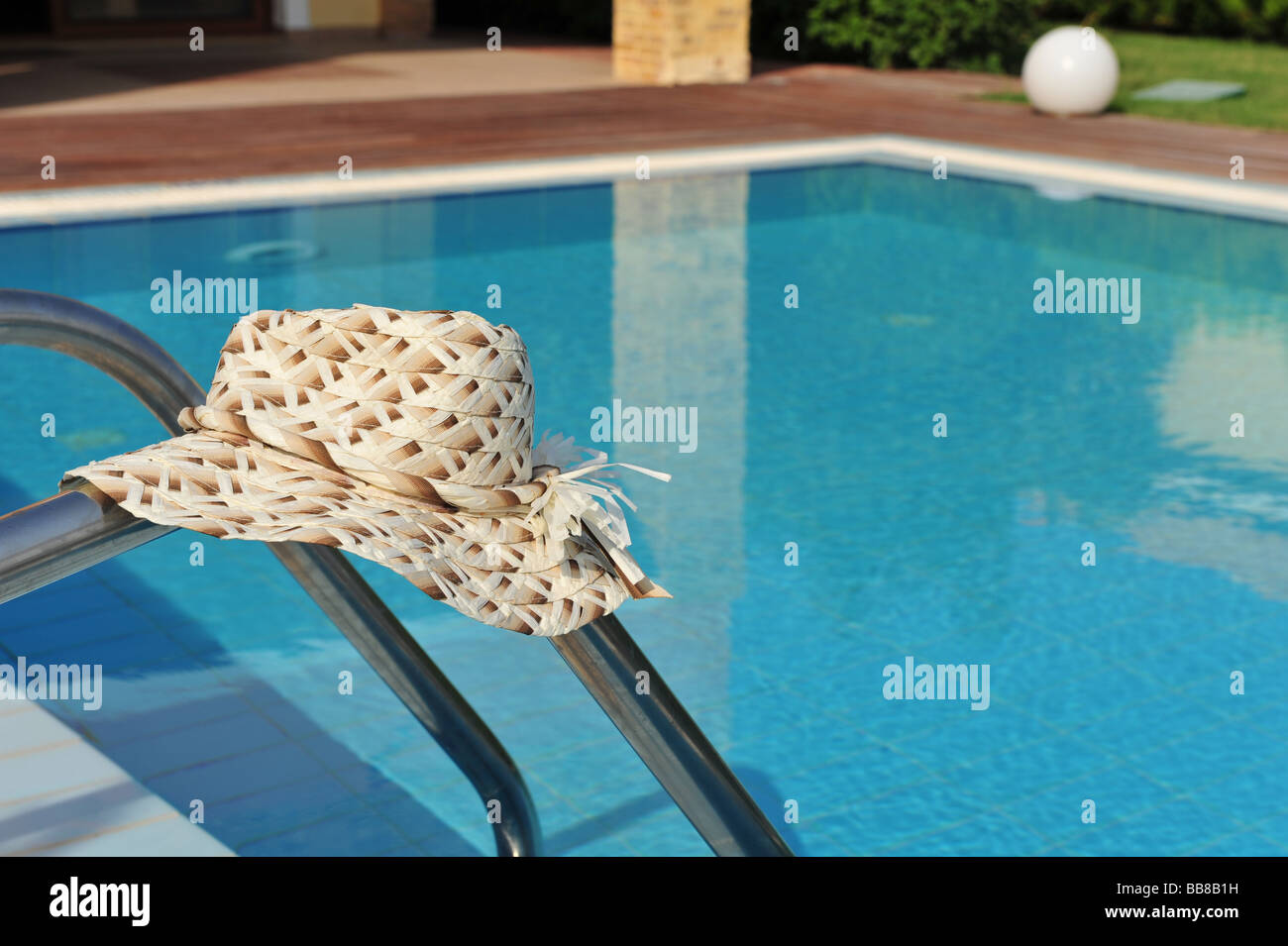 Sun hat on the steps of the swimming pool Stock Photo - Alamy