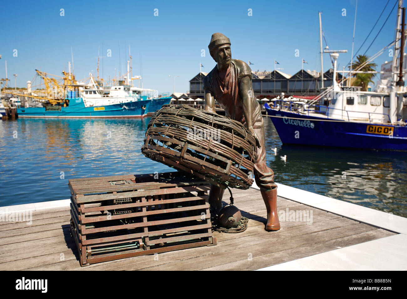 Statue of a fisherman carrying a lobster pot, on the quay at the ...