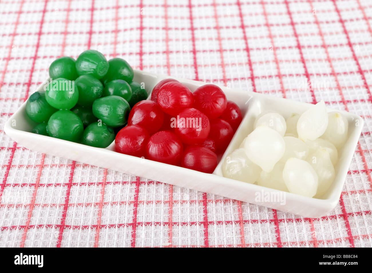 red green and white small cocktail onions on a plate ready for use ...