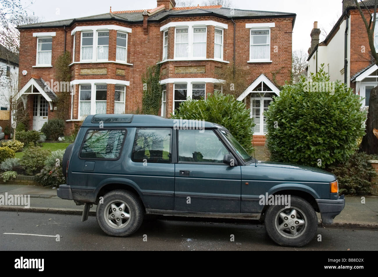 A Land Rover Discovery outside a pair of suburban semi-detached houses ...