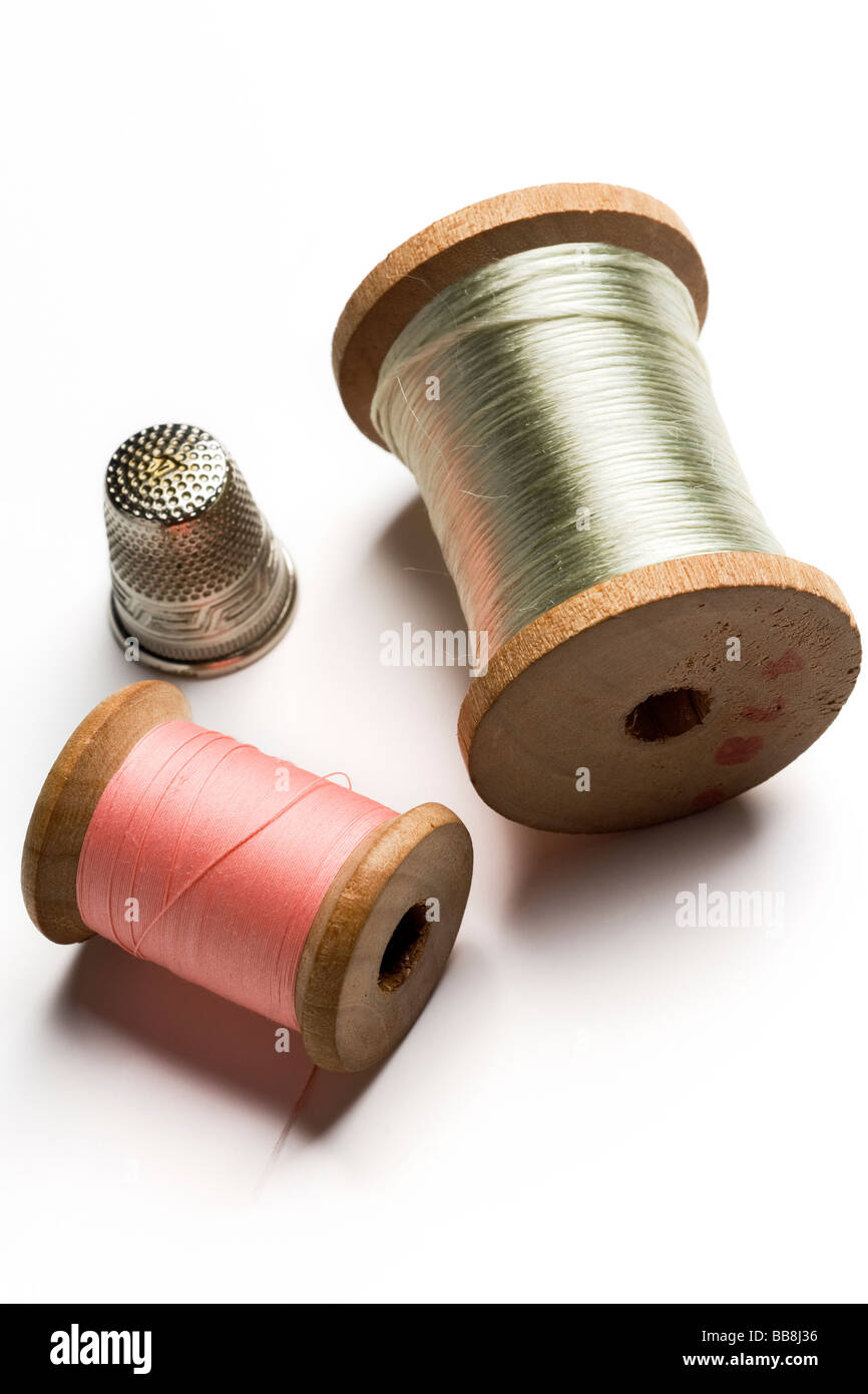 two spools of thread and a thimble on white Stock Photo - Alamy