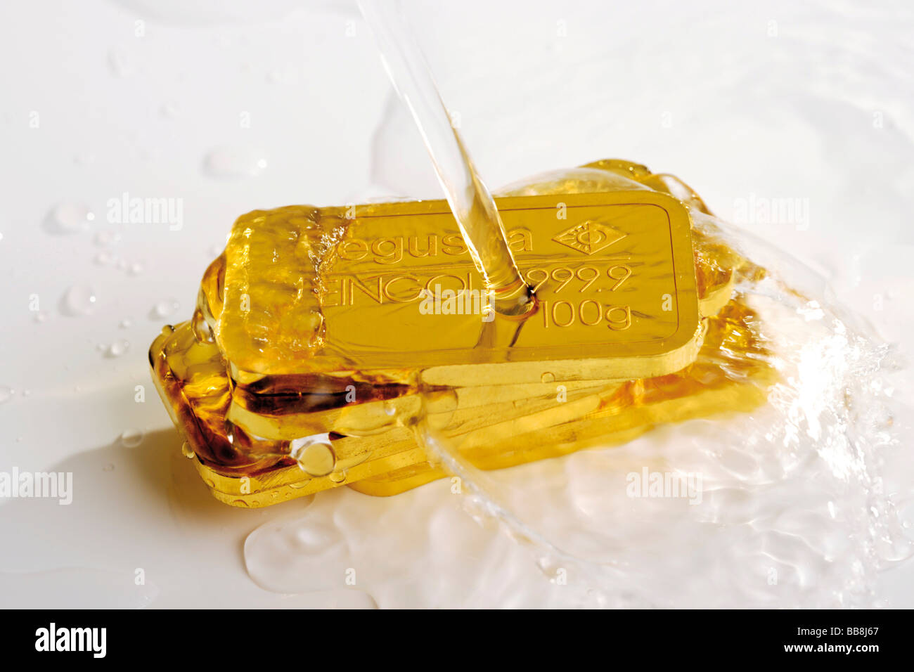 Water being poured onto a pile of gold bars Stock Photo - Alamy
