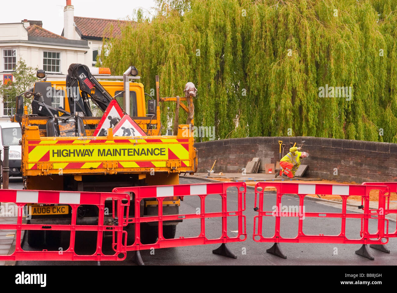 A highway maintenance lorry and workers working on the road and ...