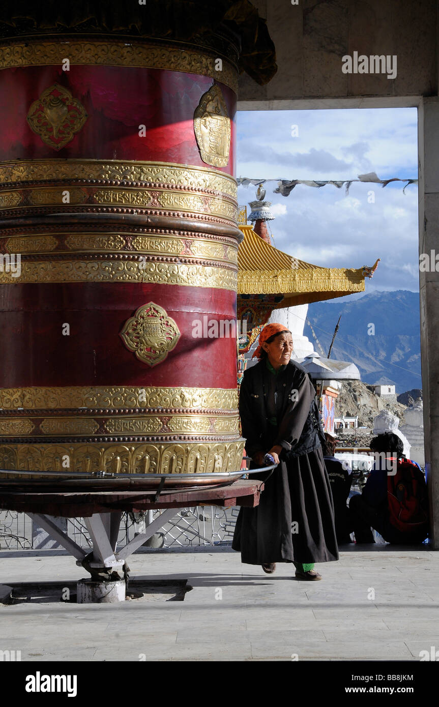 Giant prayer wheel with a Ladakhi woman wearing a traditional costume ...