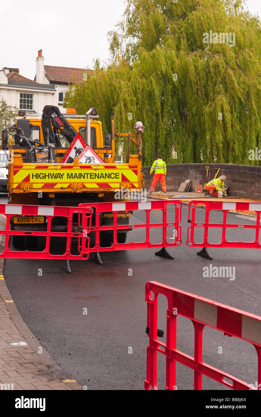 A highway maintenance lorry and workers working on the road and ...