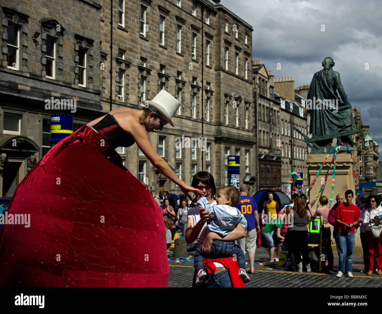 Female Street Performer on stils entertains young audience Edinburgh ...
