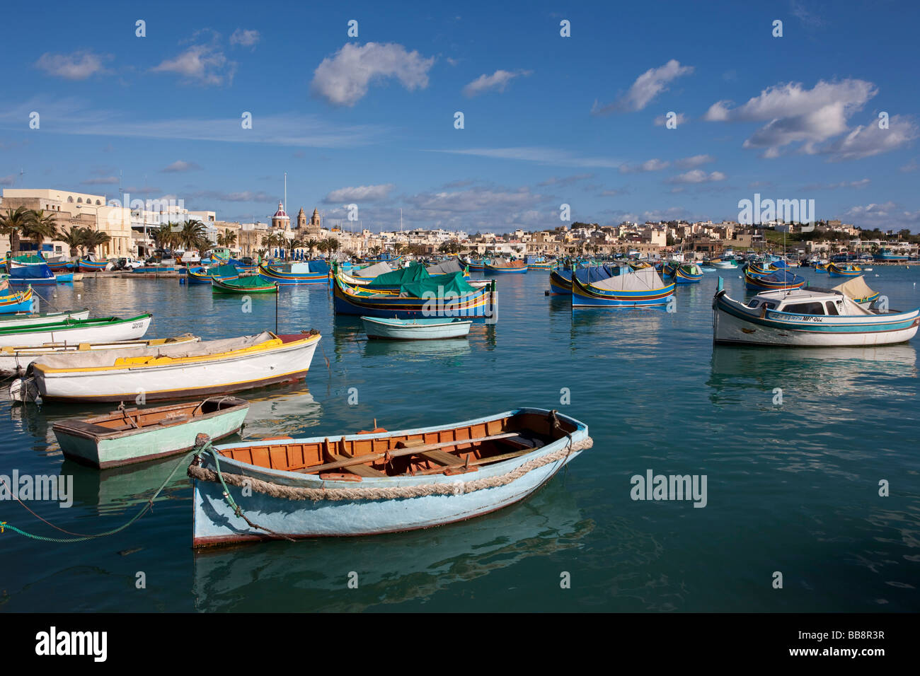 Traditional Maltese fishing boats, called Luzzu, in front of the Church ...