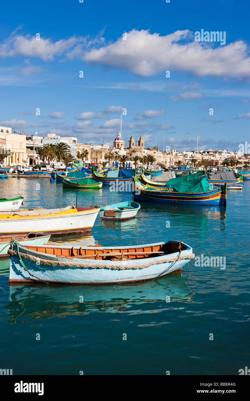 Traditional Maltese fishing boats, called Luzzu, in front of the Church ...