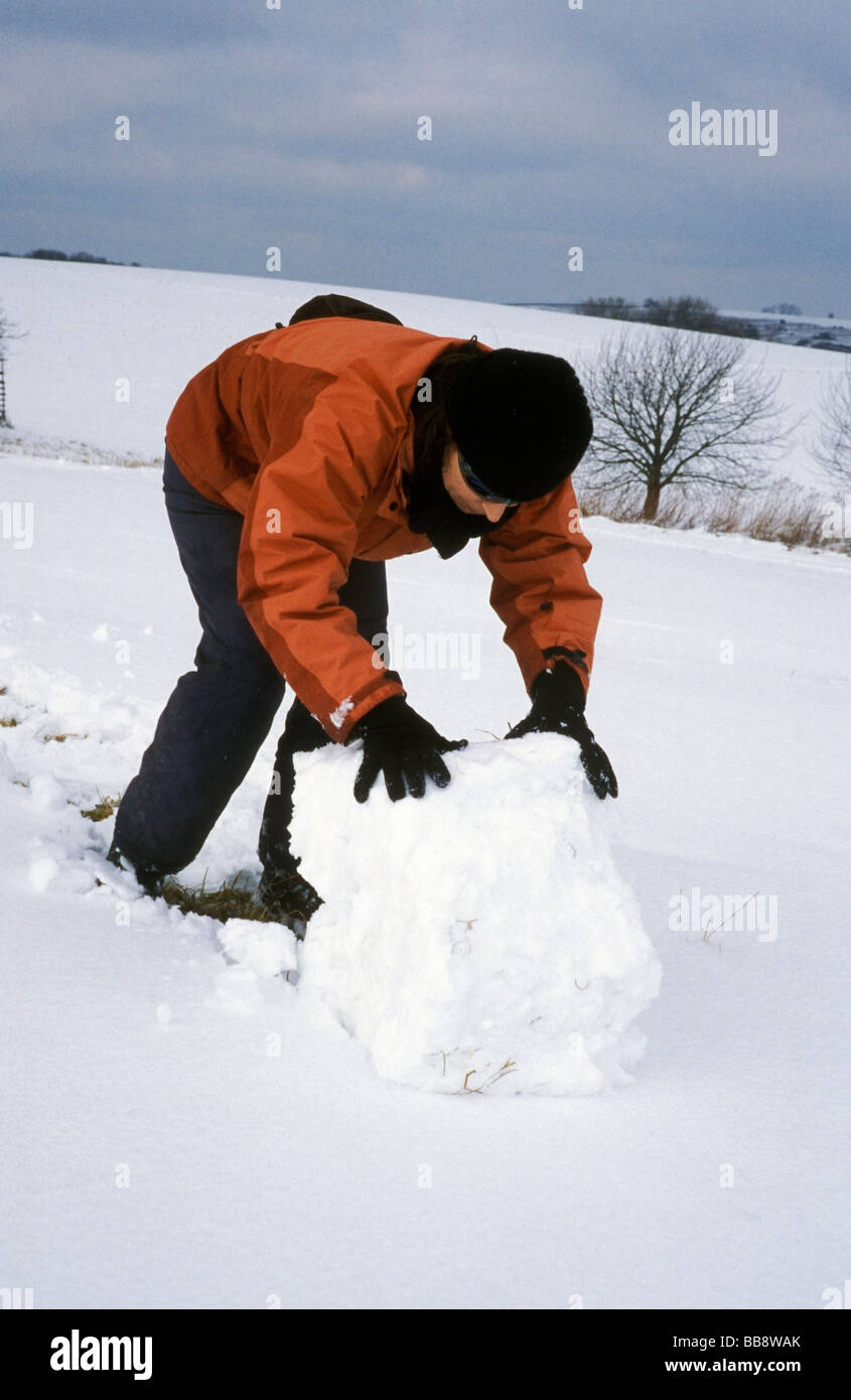 Woman rolling a snowball Germany January 2009 Stock Photo - Alamy